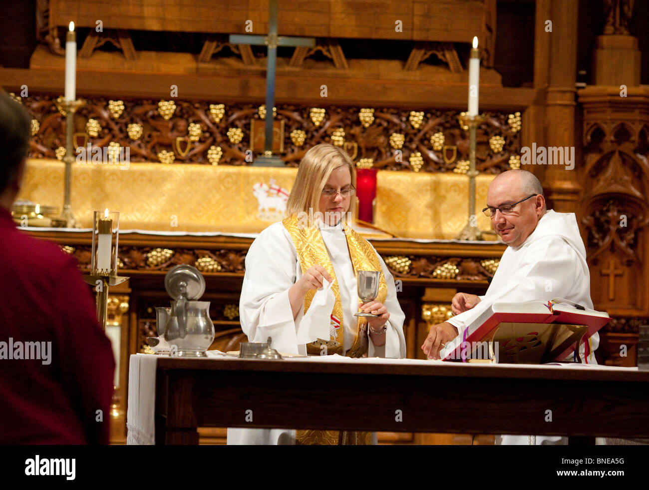 Female pastor and assistant prepare for communion during Easter Sunday ...