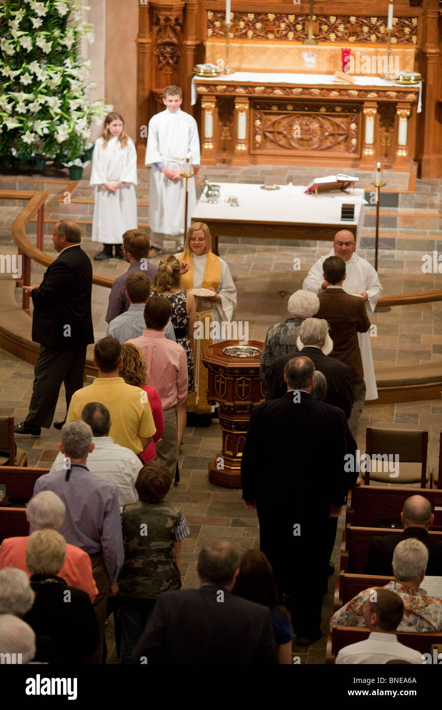 Church members walk down center aisle to alter for rite of holy ...