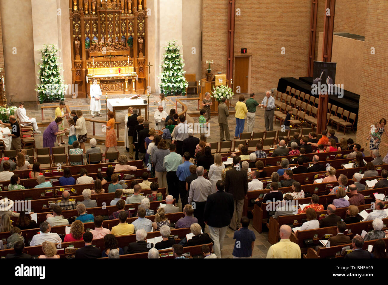 Church members walk down center aisle to alter for rite of holy ...