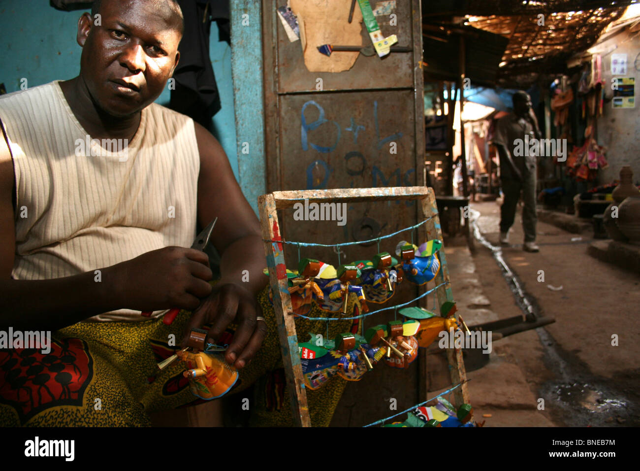 Artisan making toy angels from discarded spray cans, Bamako, Mali Stock ...