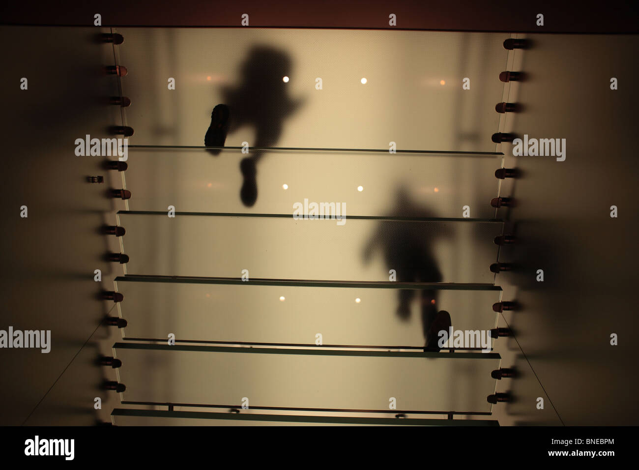 A view of people walking from underneath a transparent walkway in the ...