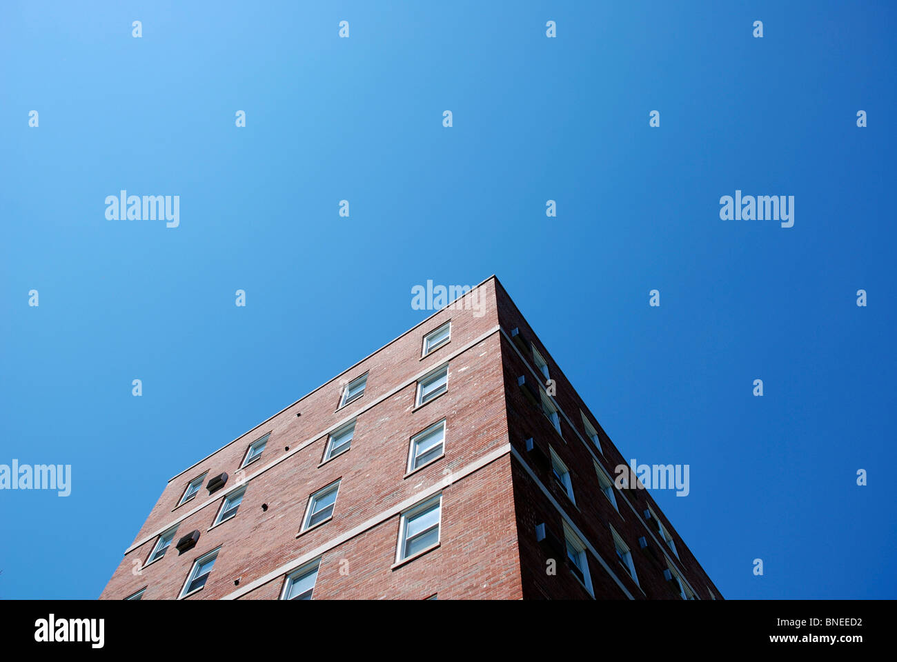 Looking up red brick building against blue sky Stock Photo - Alamy