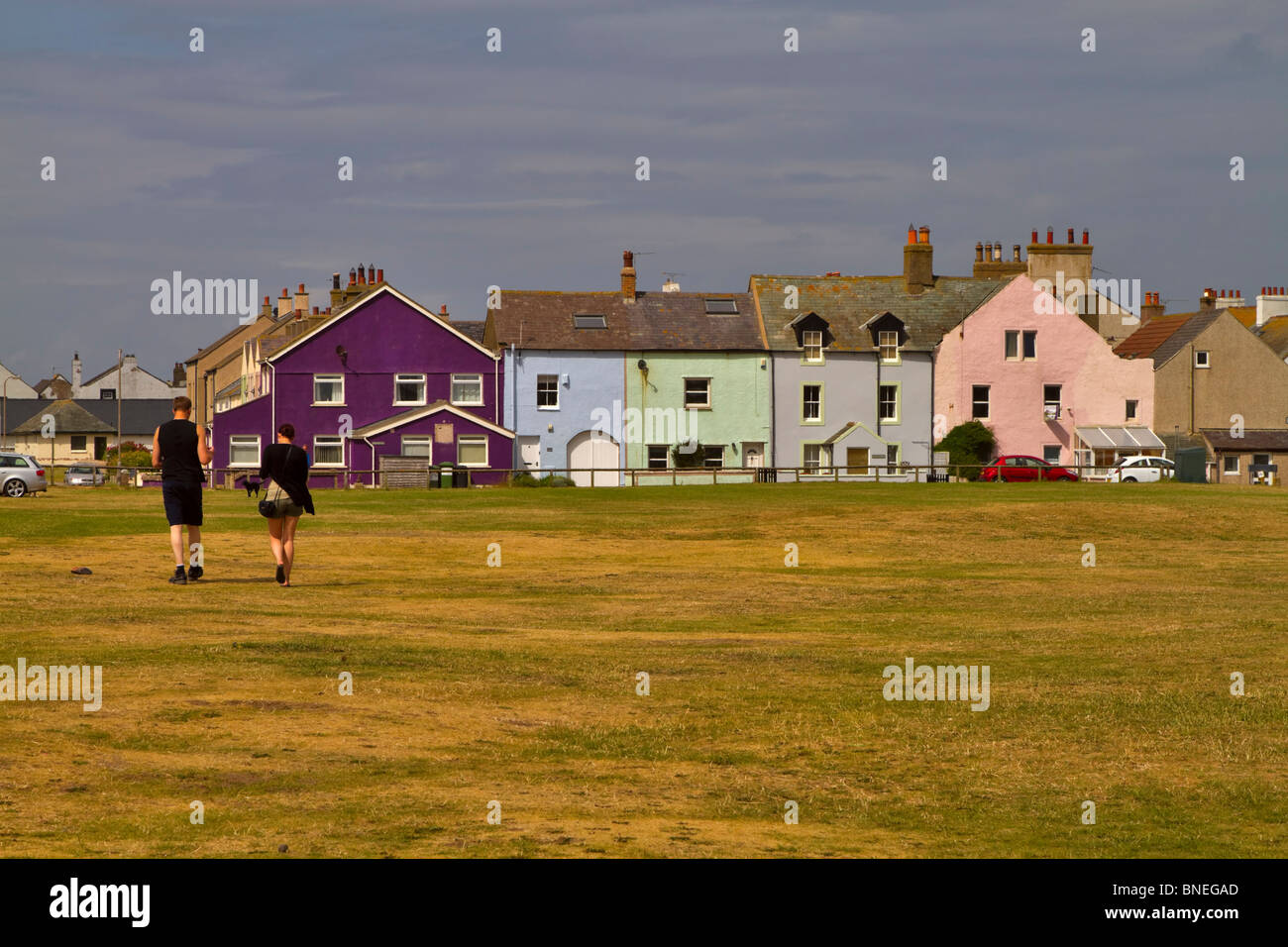 The village of Allonby, Cumbria. A couple walks across the village ...