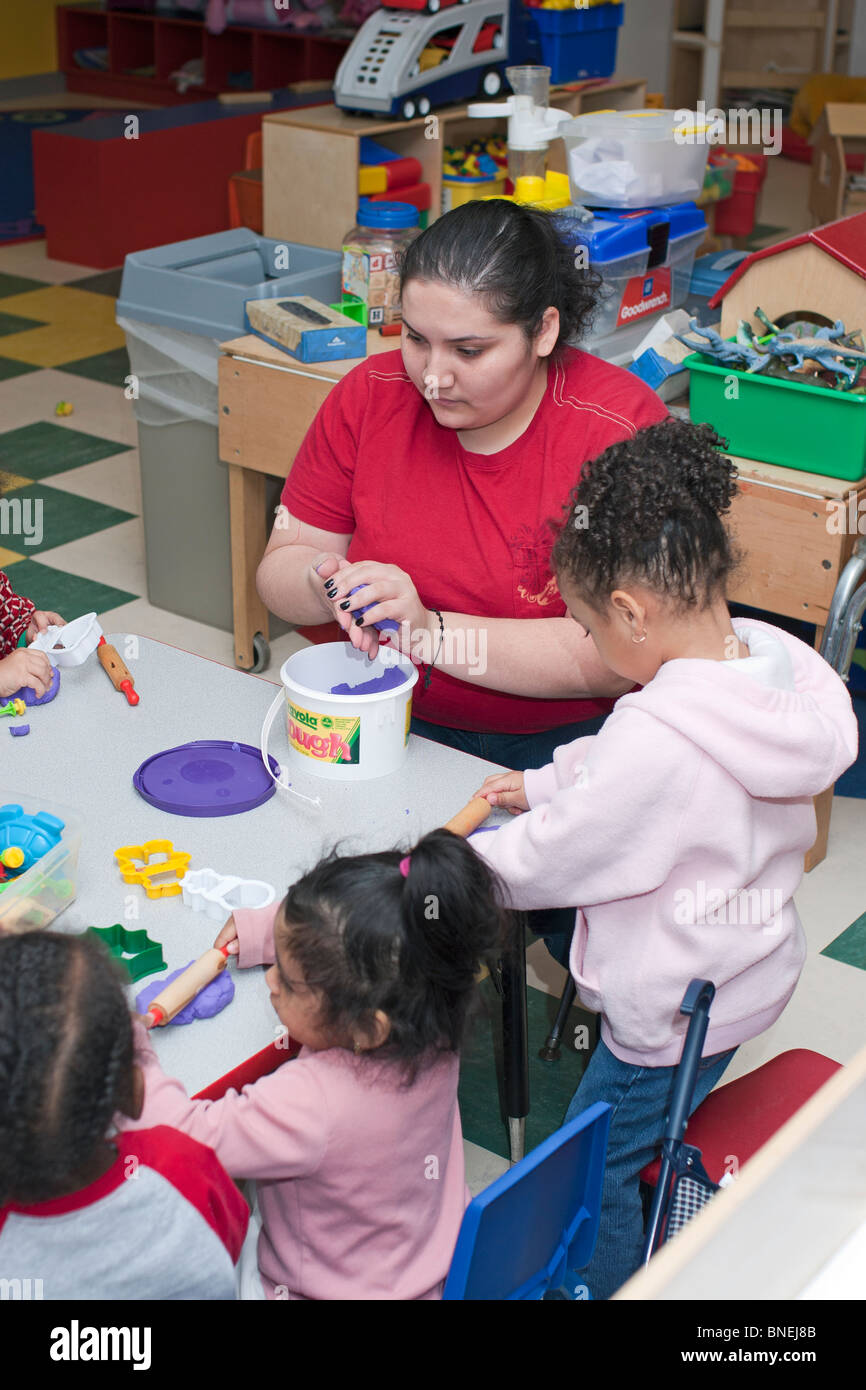 preschool classroom Preschool teacher helping her students with an art ...