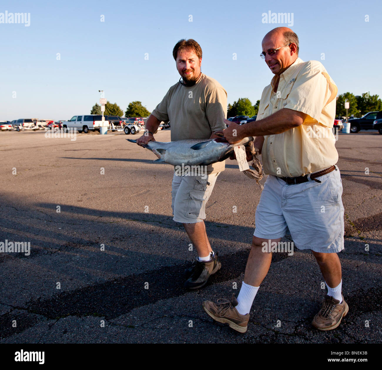 Tom Pietila, left, and Craig Bender, right, carry angler Roger Hellen's ...