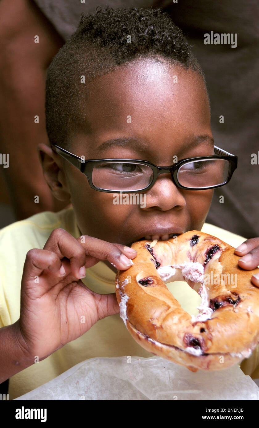 A 5-year-old boy eats a bagel in a restaurant in Arizona, USA Stock ...