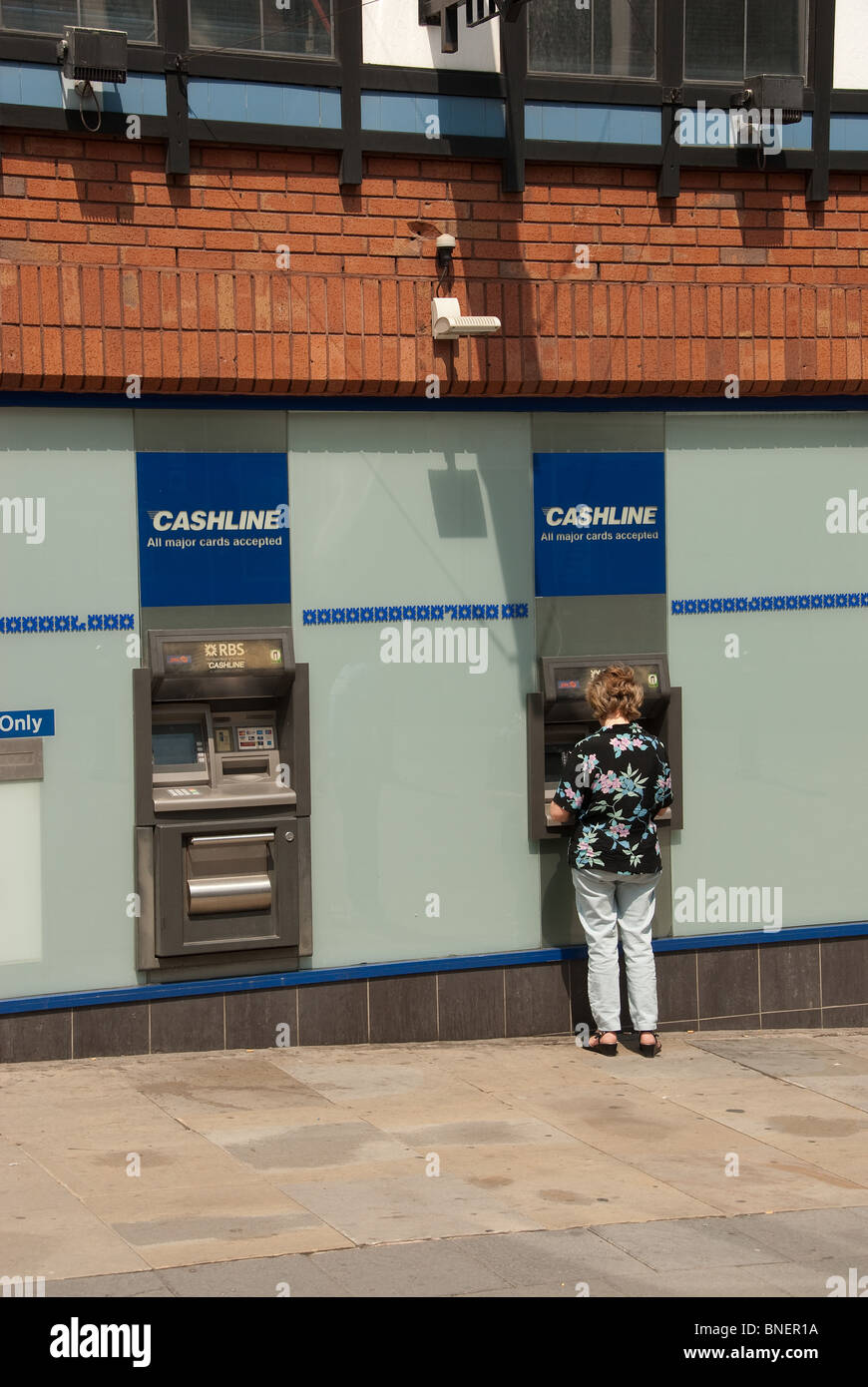 Shopper drawing cash from automatic telling machine Stock Photo - Alamy