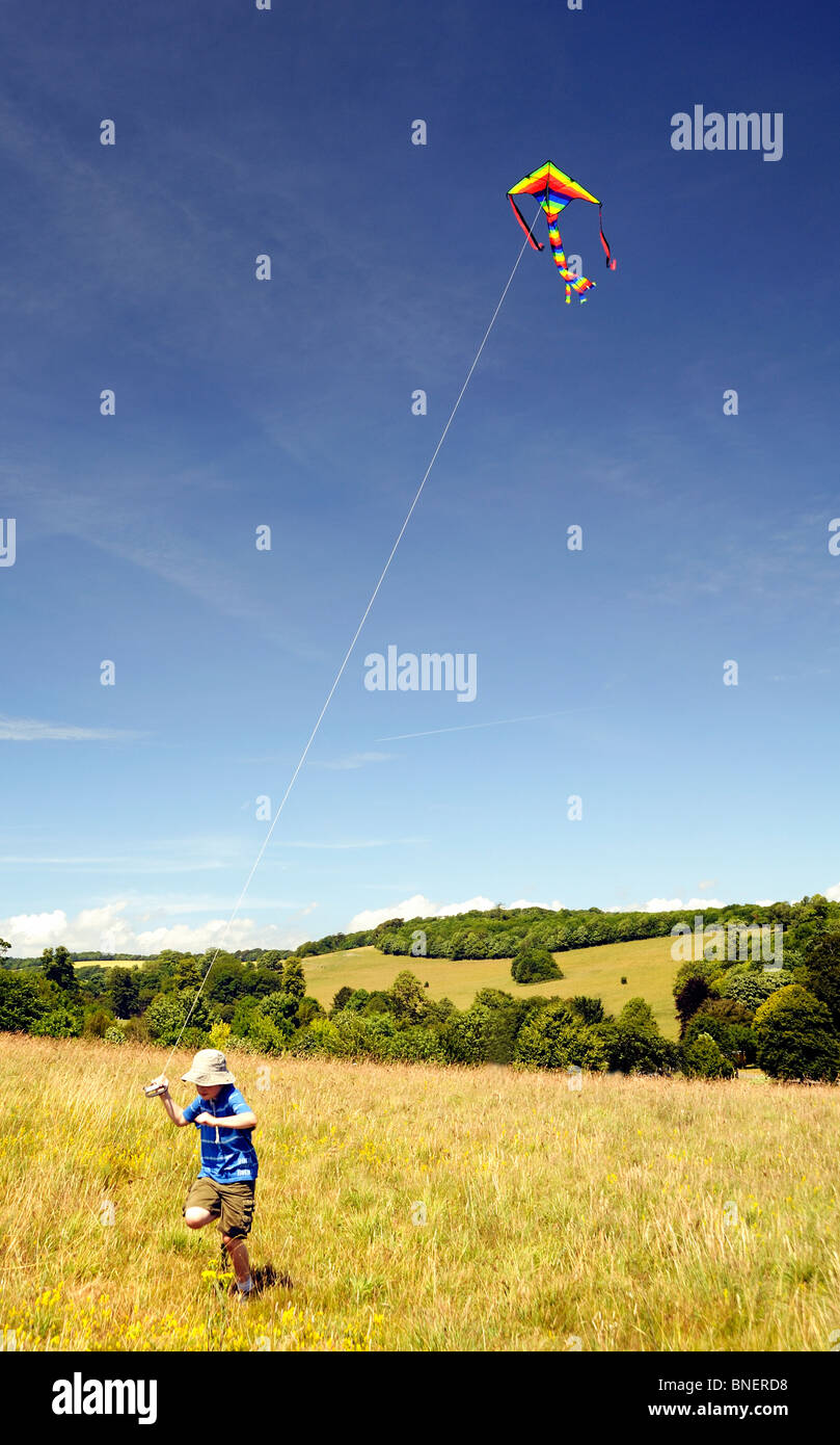 Boy running through the grass pulling a Kite behind him Stock Photo - Alamy