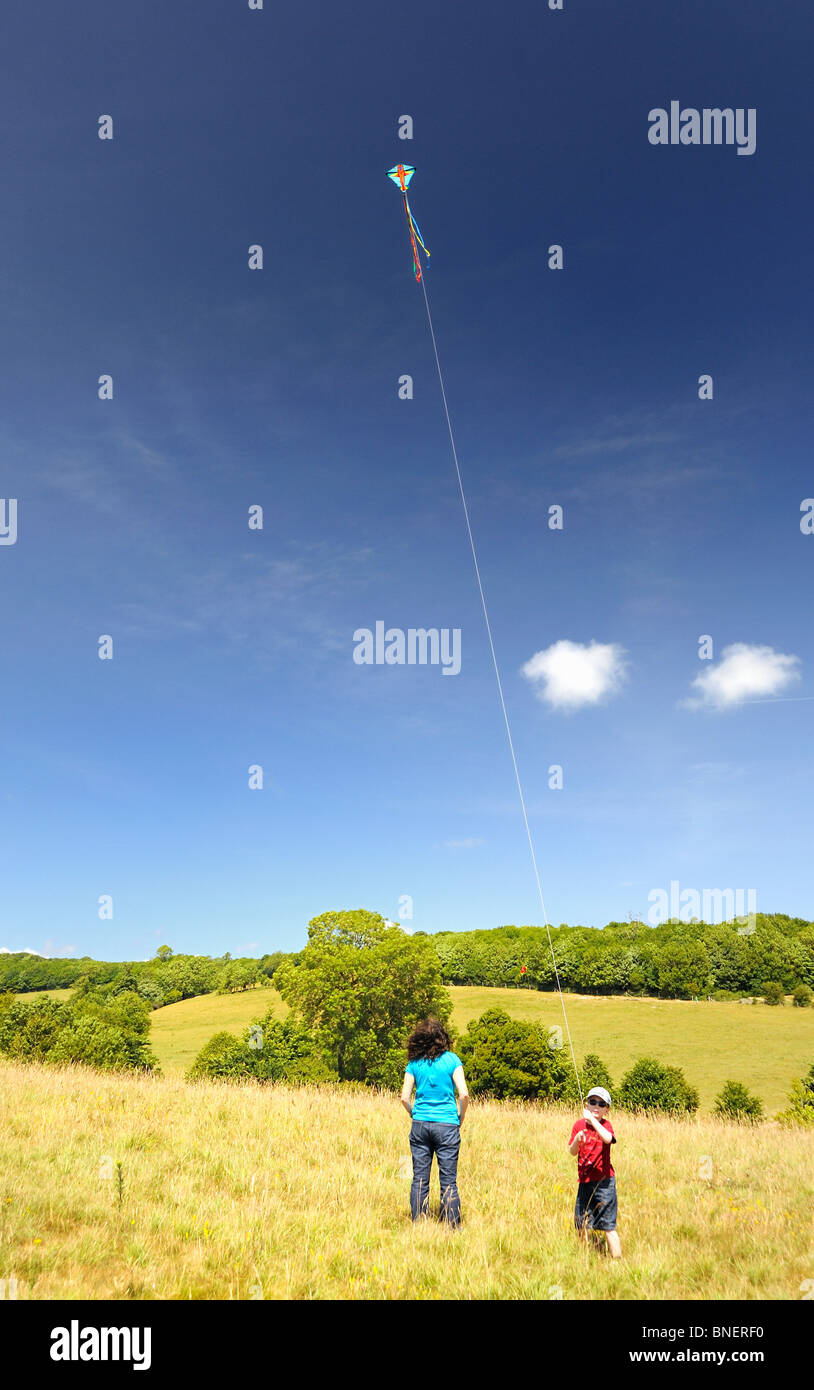 Mother watching and young child flying a kite Stock Photo - Alamy
