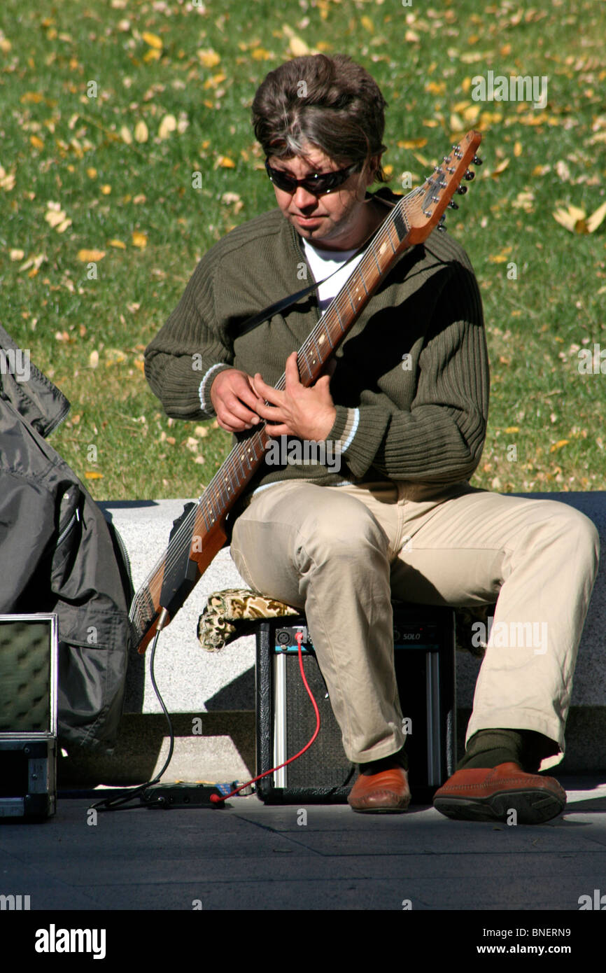 Musician playing a 'Chapman stick' connected to an amplifier outside of ...