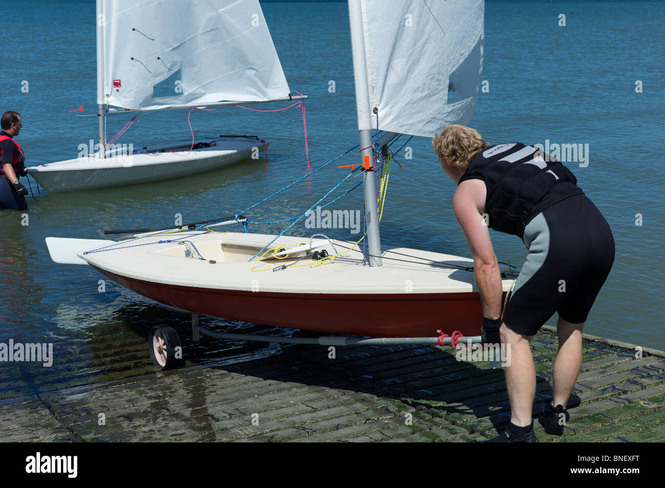 Launching sailing dingys from the jetty Stock Photo - Alamy