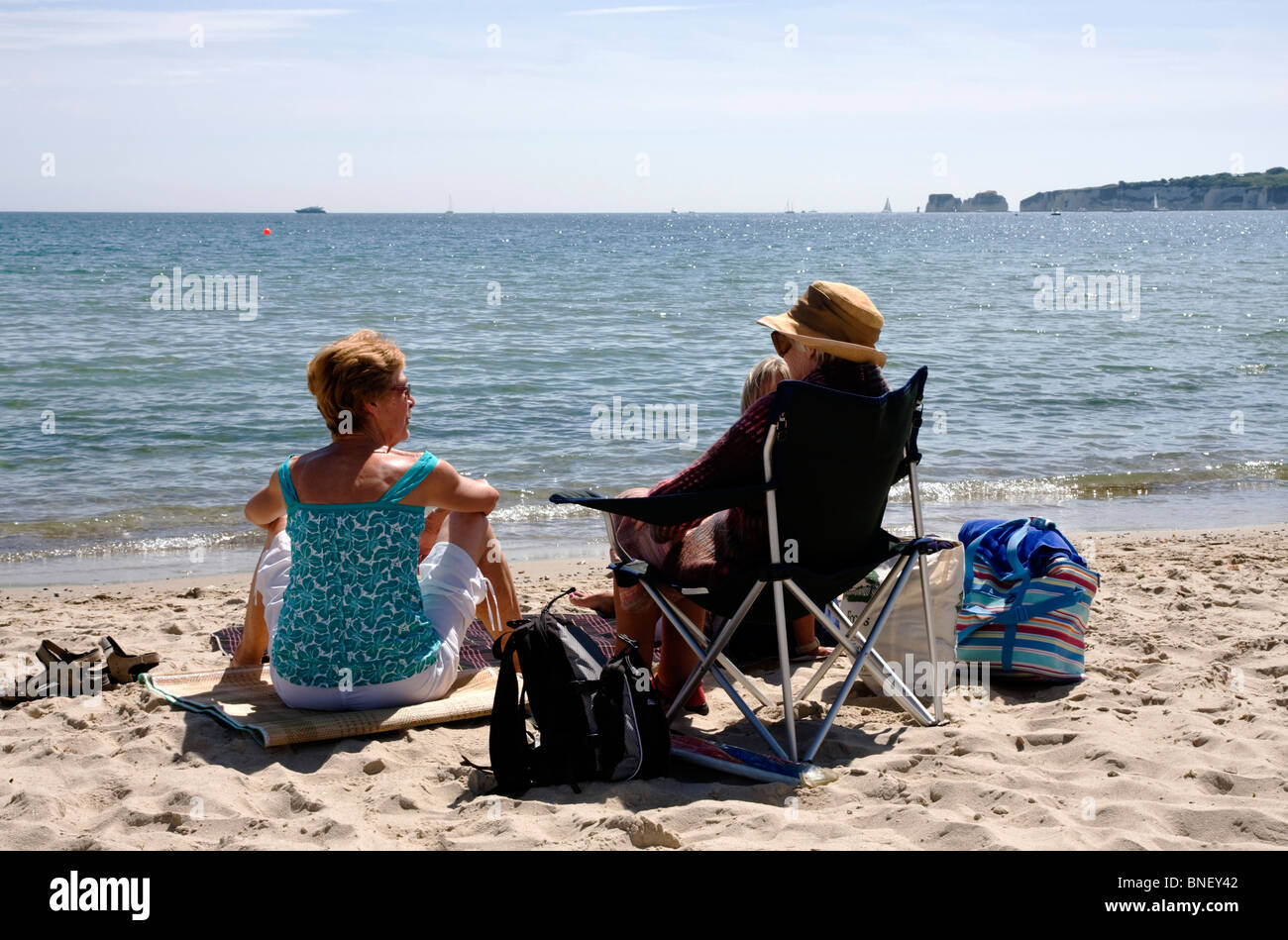 Two people relaxing on sandy beach, Studland, Isle of Purbeck, Dorset ...
