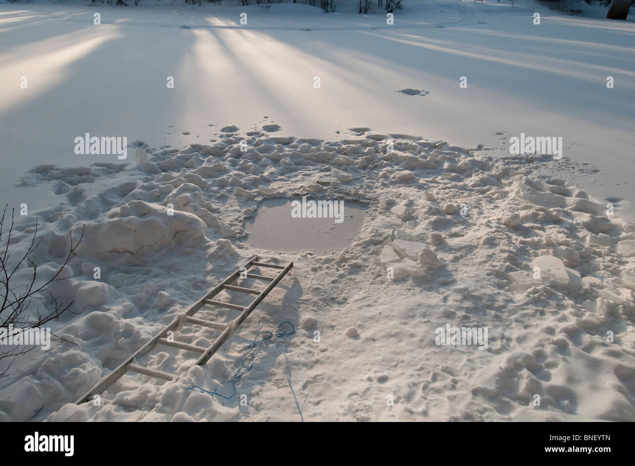 Frozen lake with a hole drilled open which is already frozen again ...