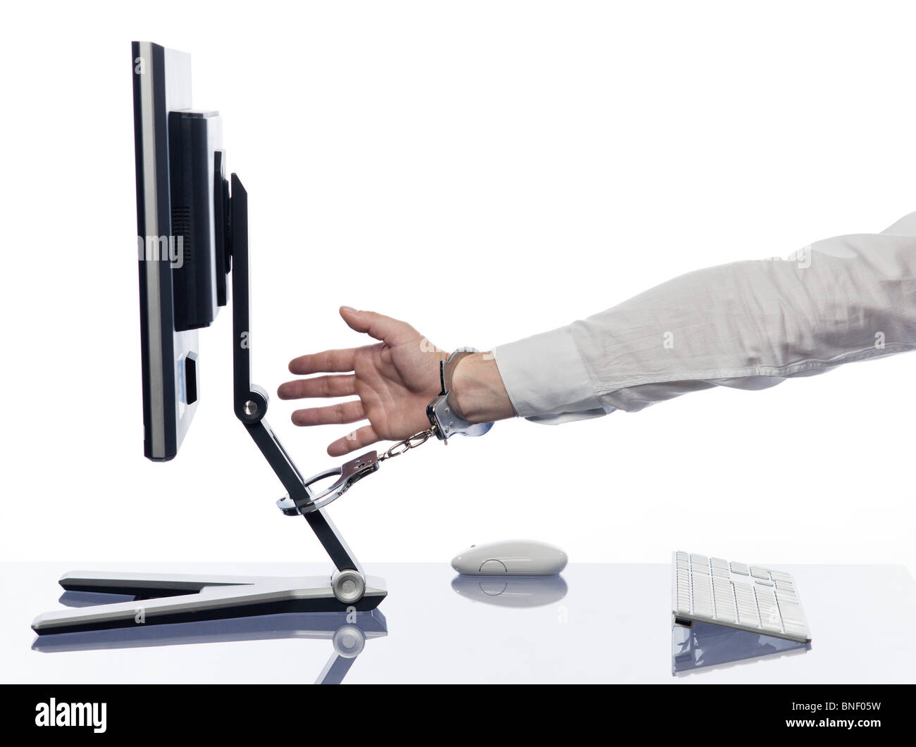 hand chained to computer with handcuffs expressing addiction concept ...
