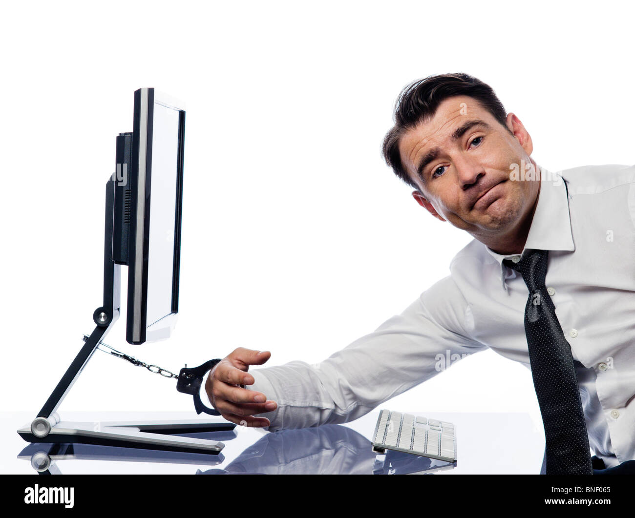 one caucasian man chained to computer with handcuffs expressing ...