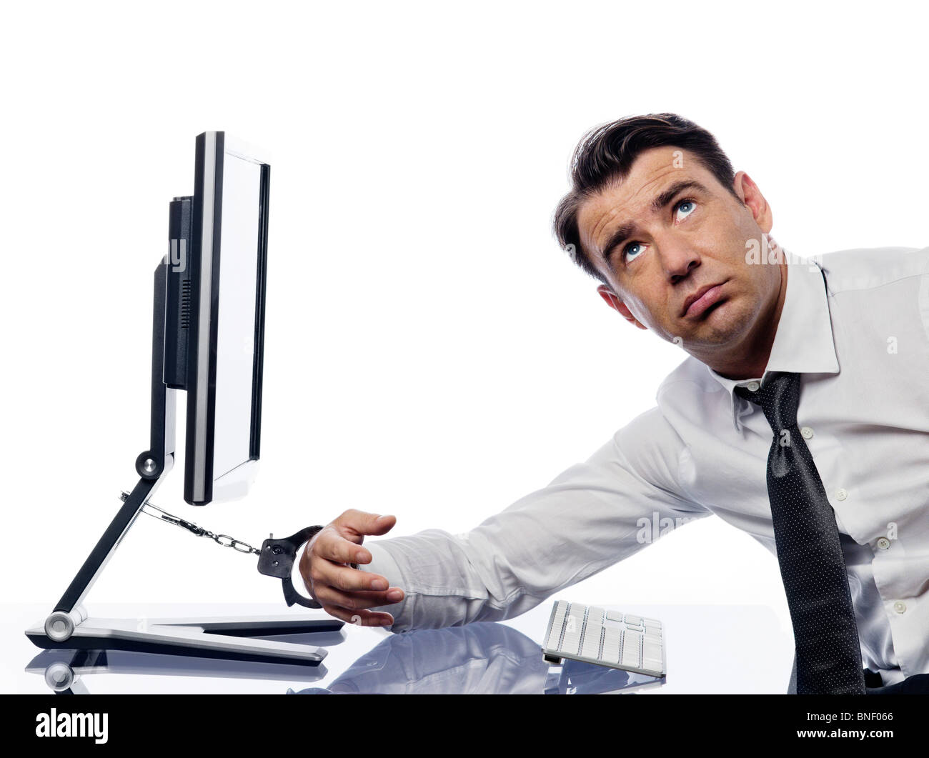 one caucasian man chained to computer with handcuffs expressing ...