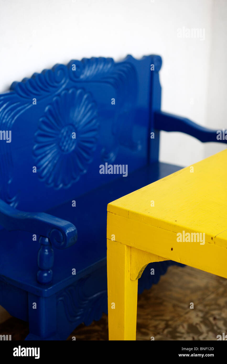 A yellow table and blue bench against a white wall Stock Photo - Alamy
