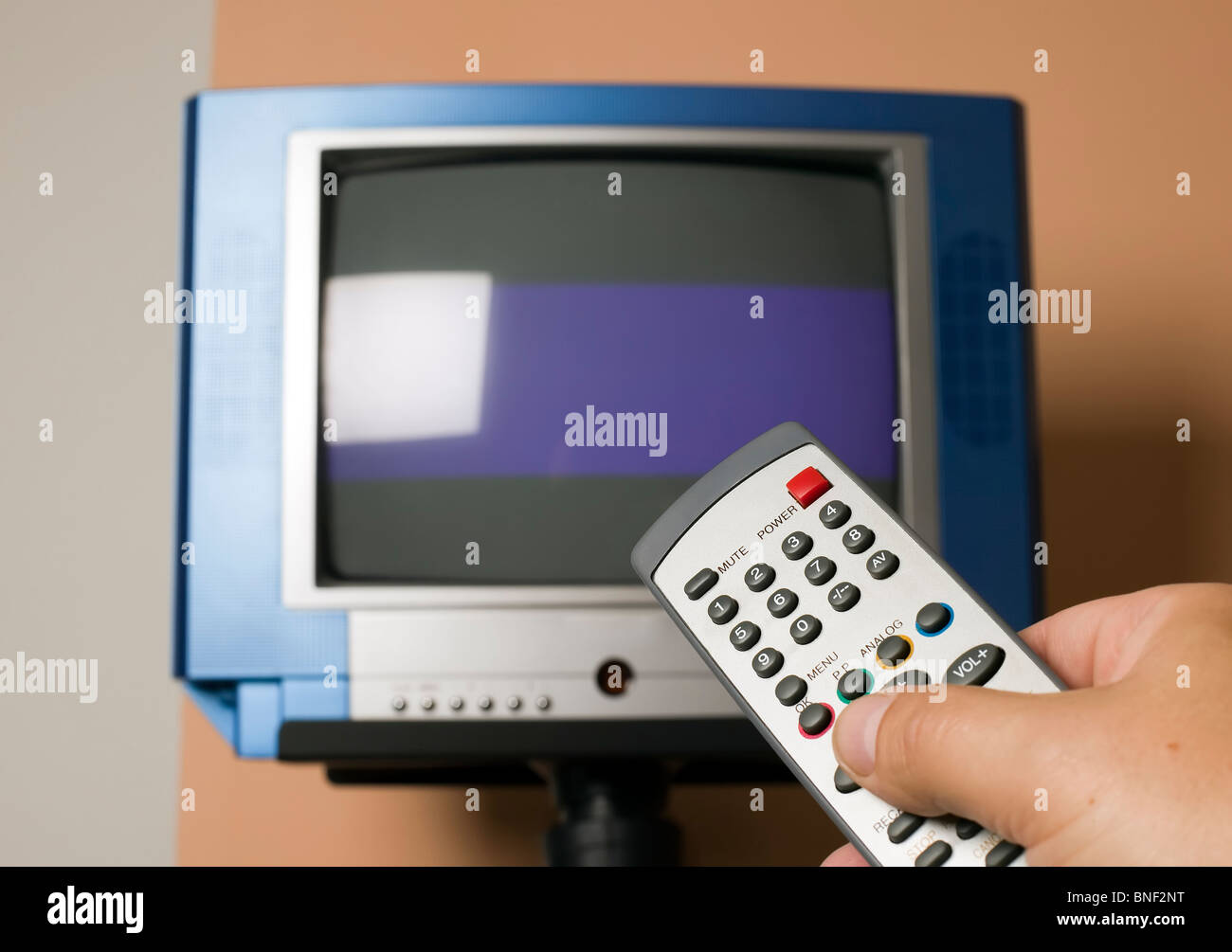 Man with remote is watching television program Stock Photo - Alamy