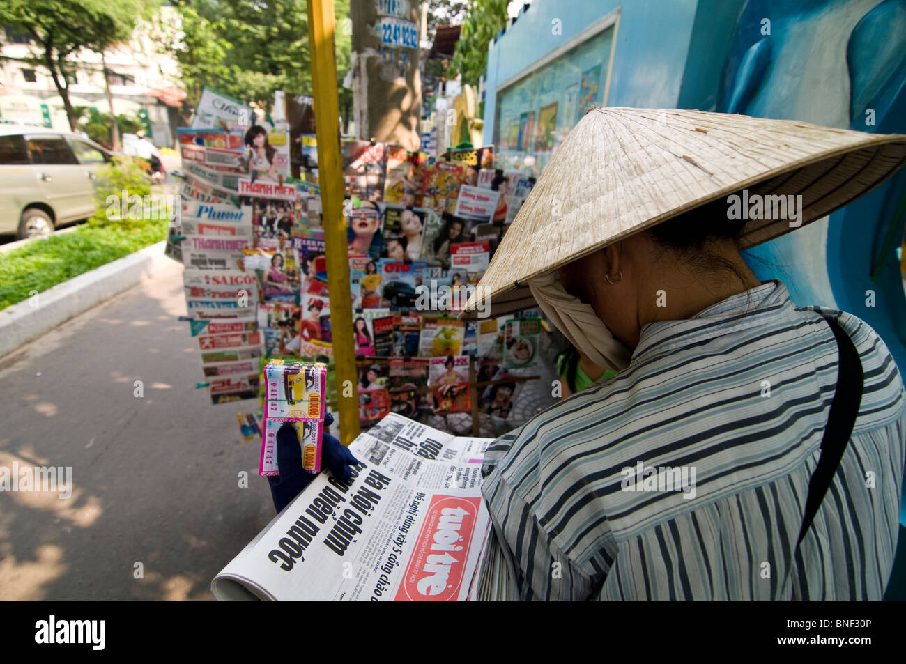 Newspaper seller in the streets of Saigon Stock Photo - Alamy