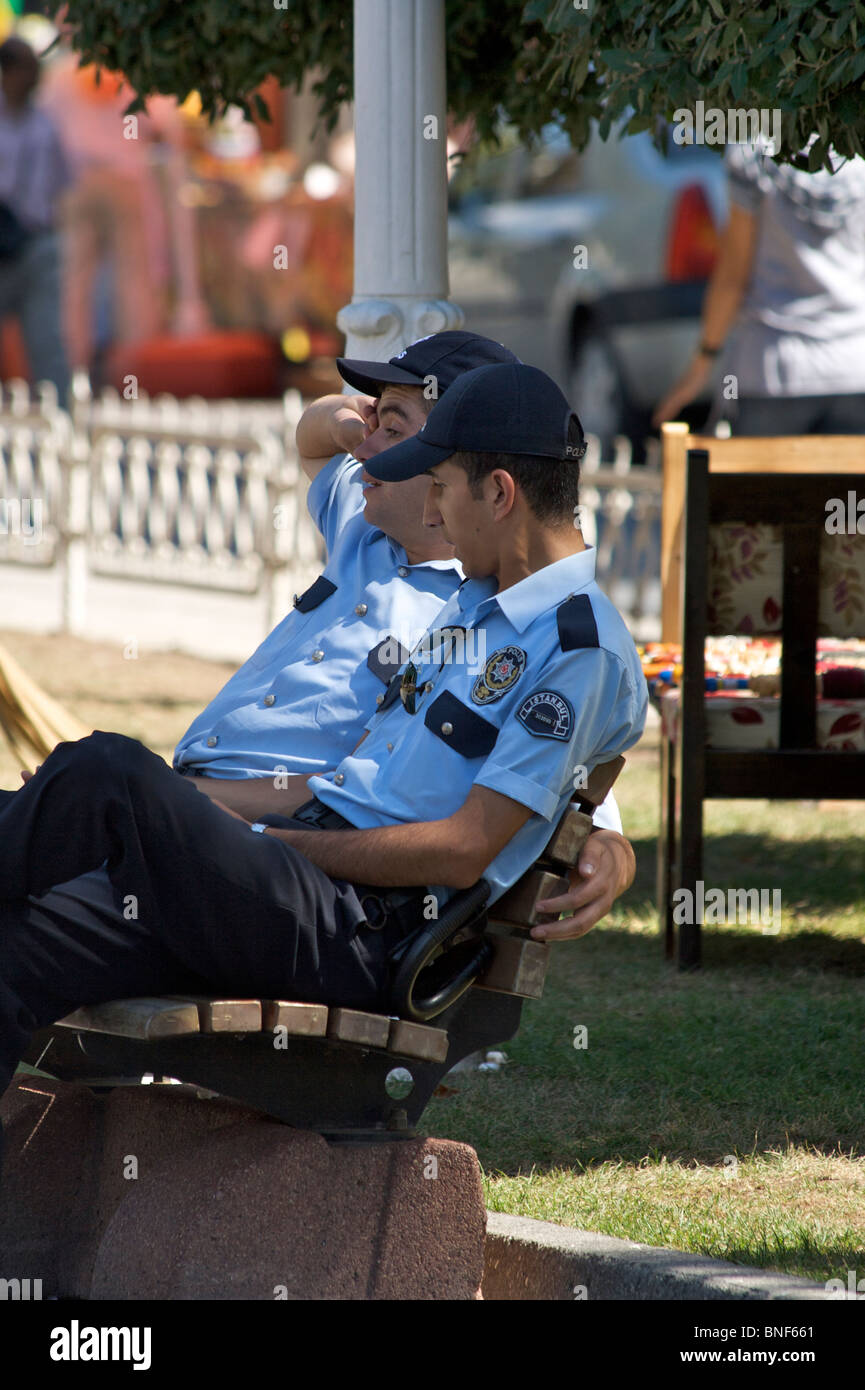 Two Turkish police (Polis) officers resting in the shade on a wooden ...