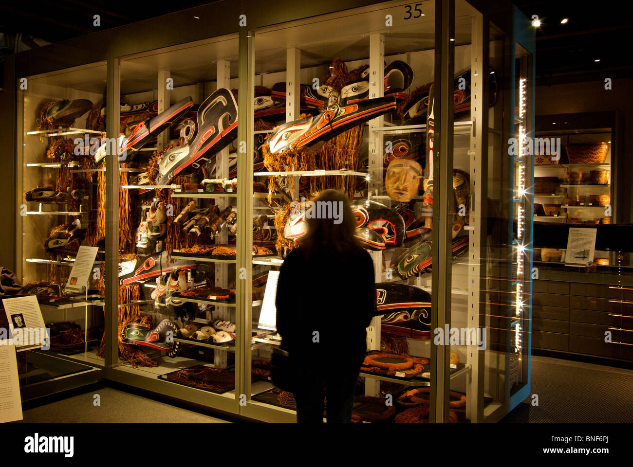 Woman looking at display of west coast First Nations ceremonial masks ...