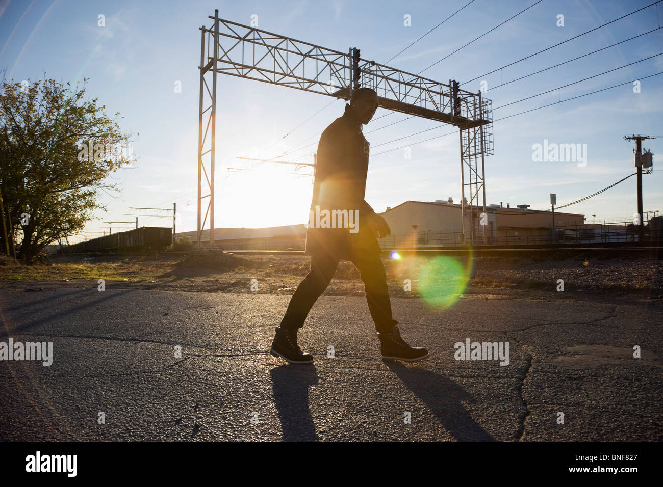 Young man walking on the road Stock Photo - Alamy