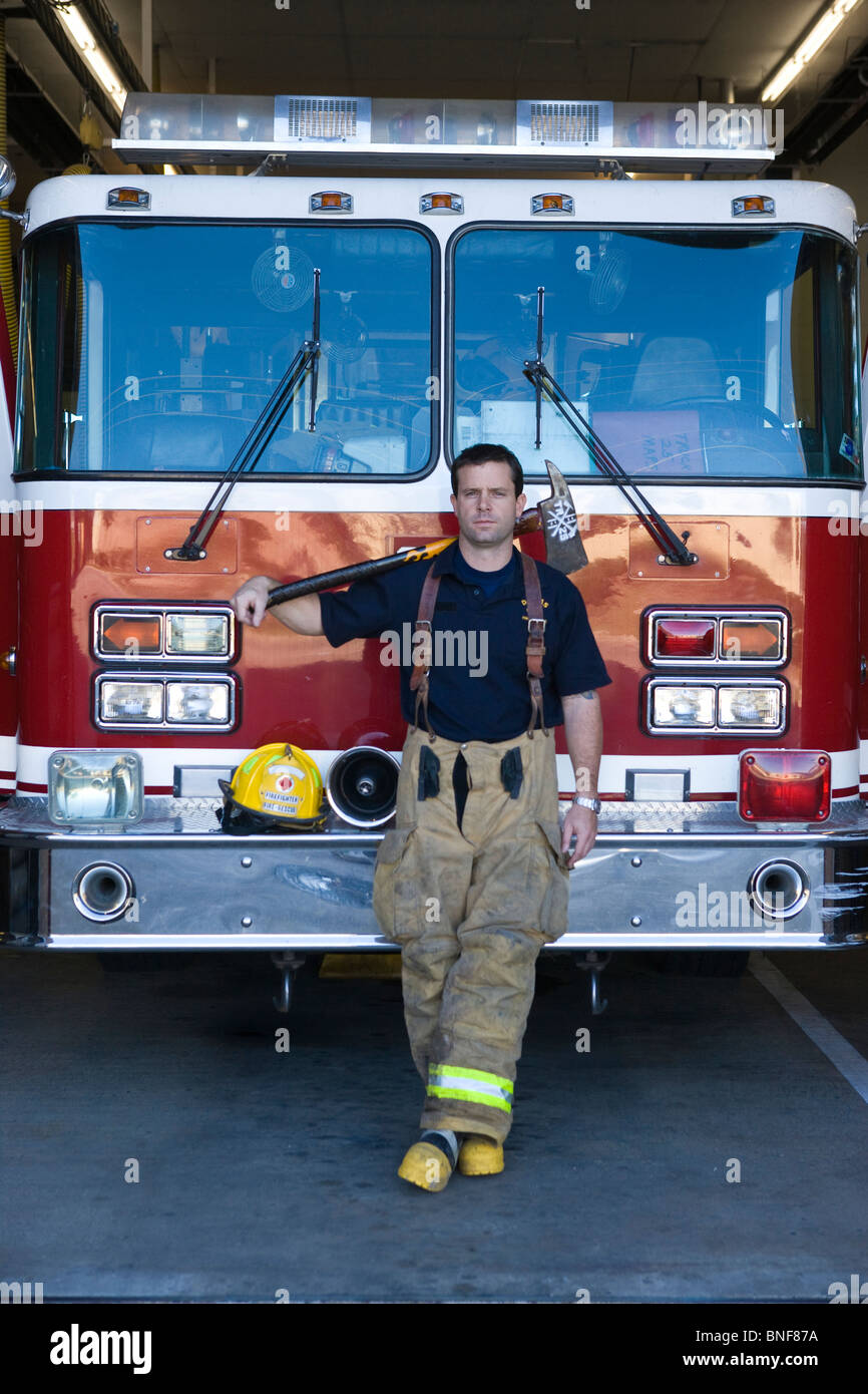 Firefighter standing in front of a fire engine Stock Photo - Alamy