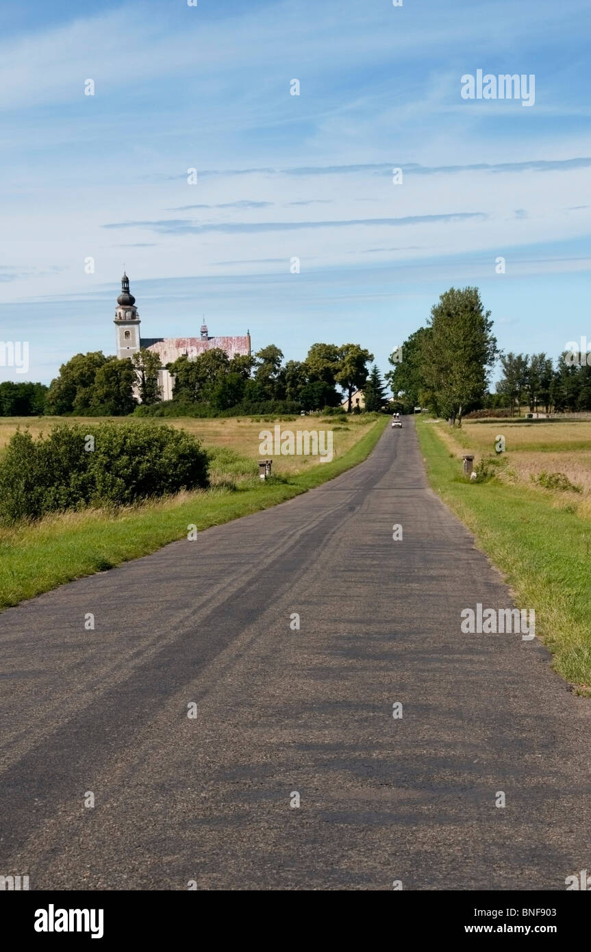 Portrait of rural countryside road, lane with view of a village church ...
