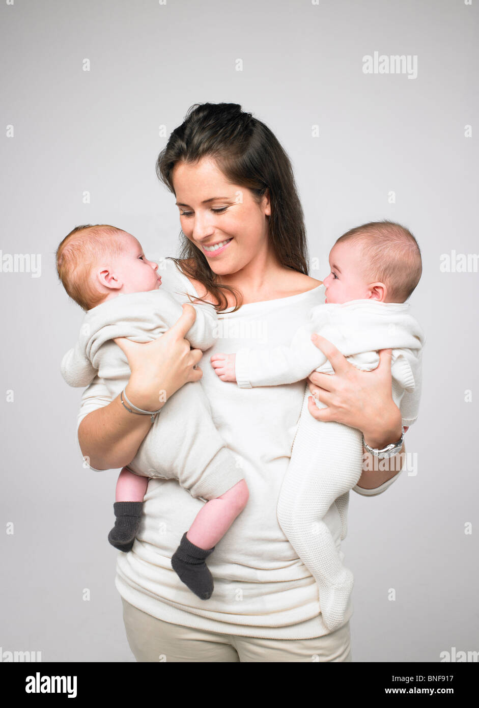 Mother holding two babies Stock Photo - Alamy