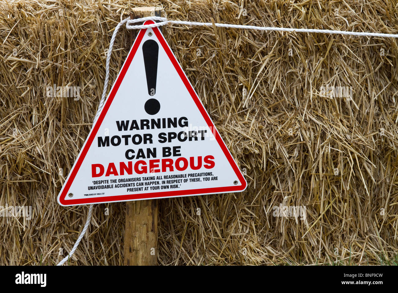 Warning motor sport can be dangerous sign Straw Bales Stock Photo - Alamy