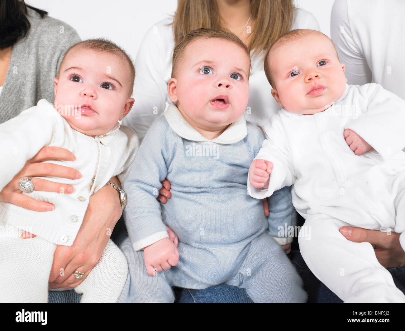 Three babies with mothers Stock Photo - Alamy