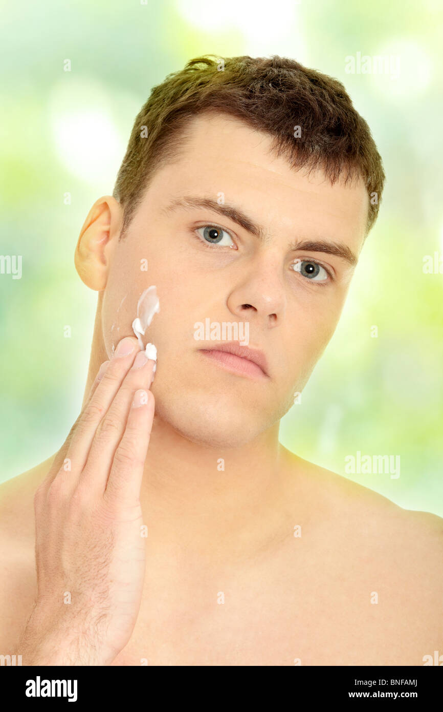Happy man after shaving applying moisturizing cream upon his face Stock ...