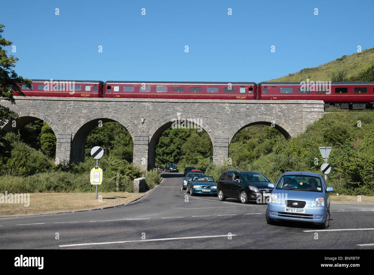 Train carriages cross the railway viaduct, part of the Swanage rail ...