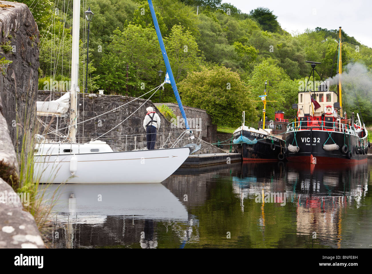 Yacht enters Crinan canal basin Stock Photo - Alamy