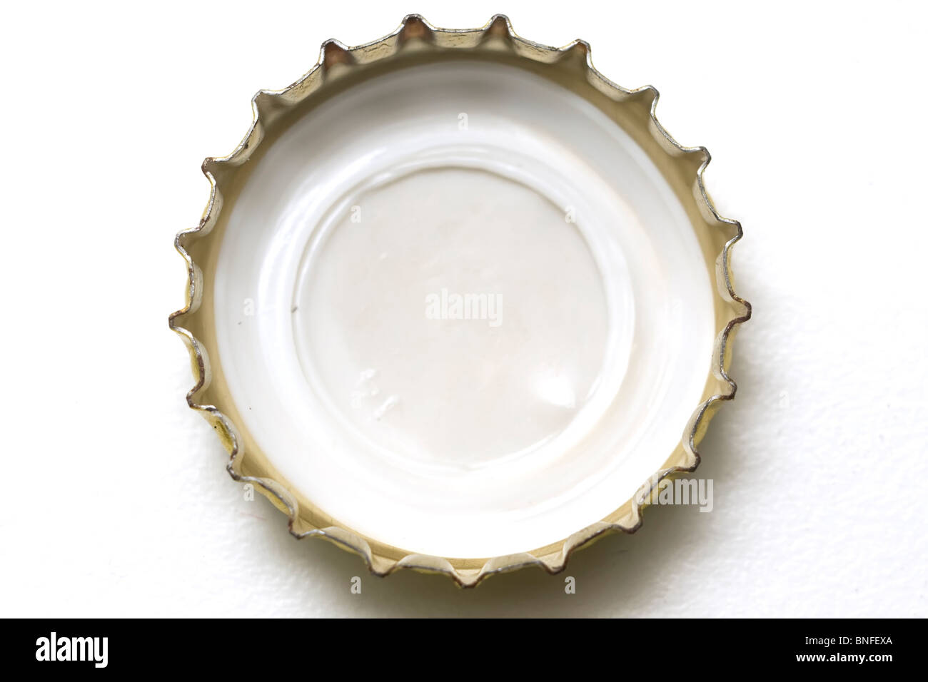 Golden beer cap macro over white background Stock Photo - Alamy