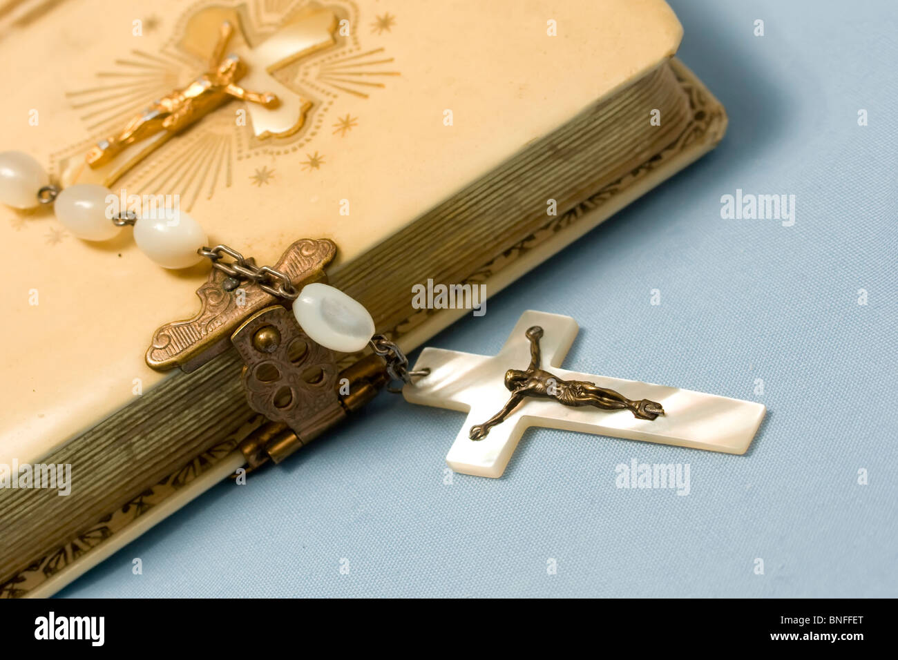 Cross and religious book over blue fabric Stock Photo - Alamy