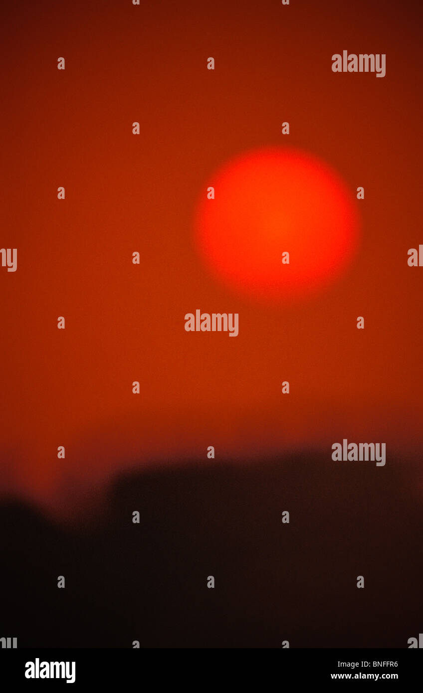 Bright red sun on horizon at sunset Stock Photo - Alamy