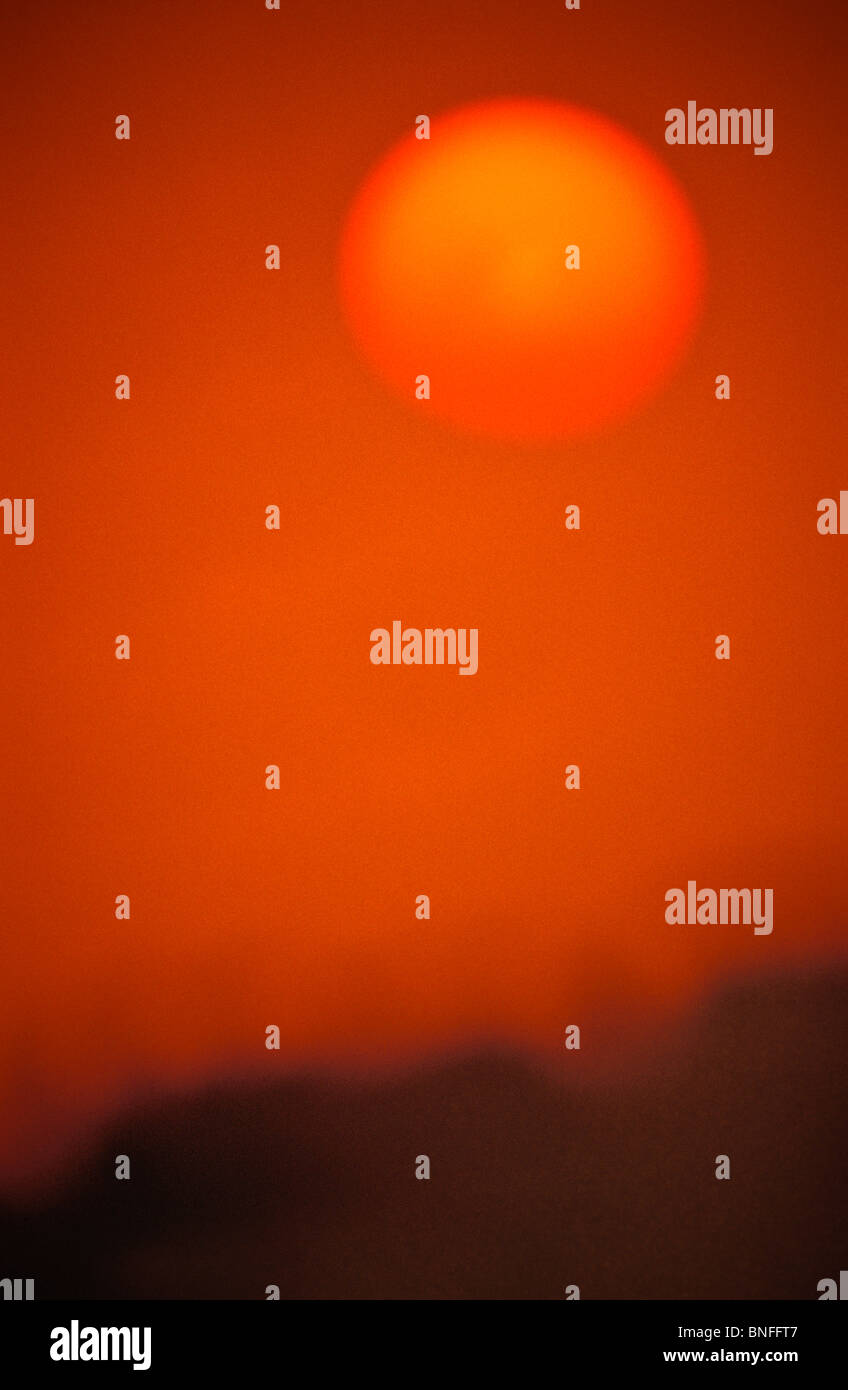 Bright red sun on horizon at sunset Stock Photo - Alamy