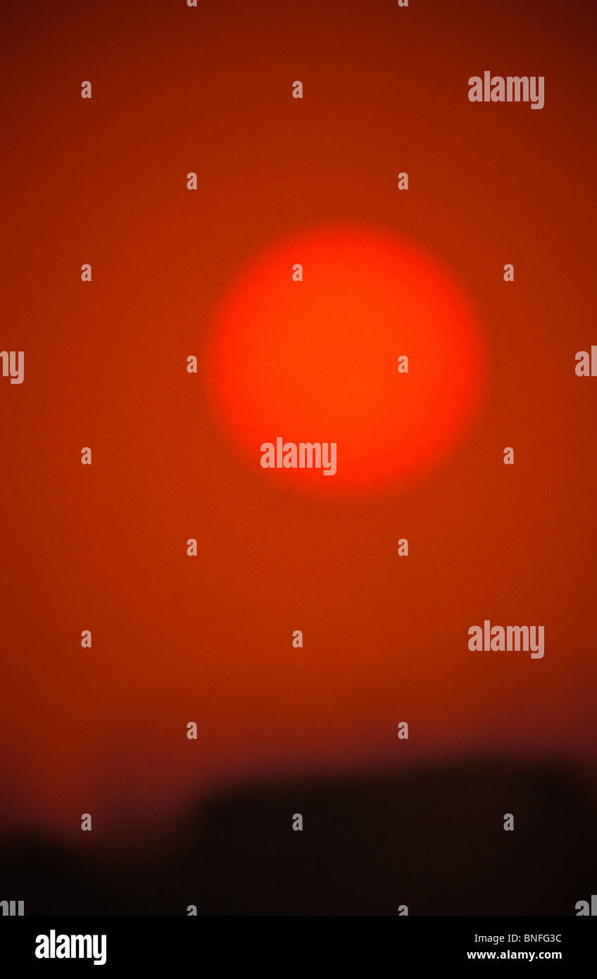 Bright red sun on horizon at sunset Stock Photo - Alamy
