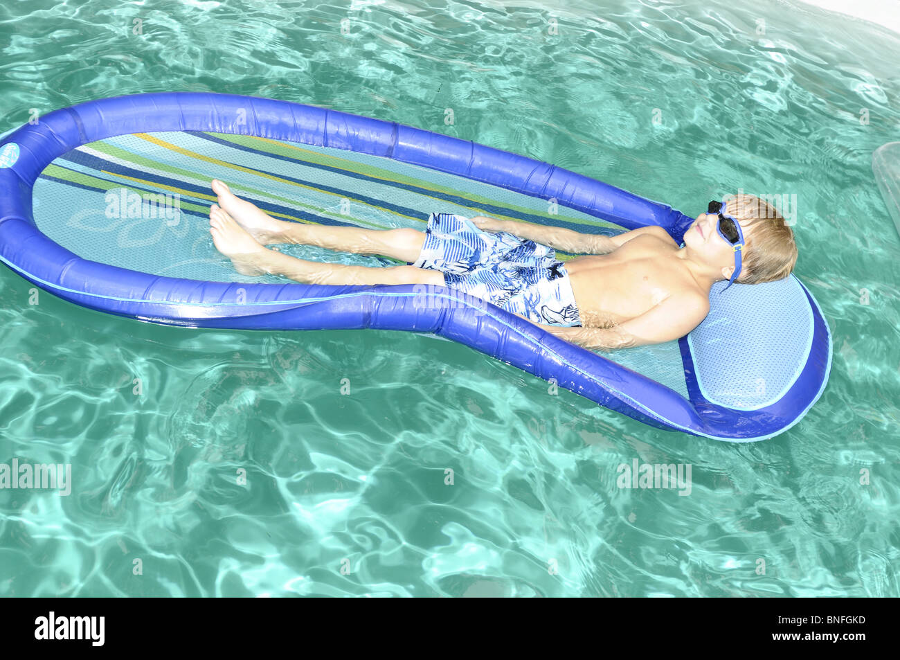 Young boy relaxing in pool Stock Photo - Alamy