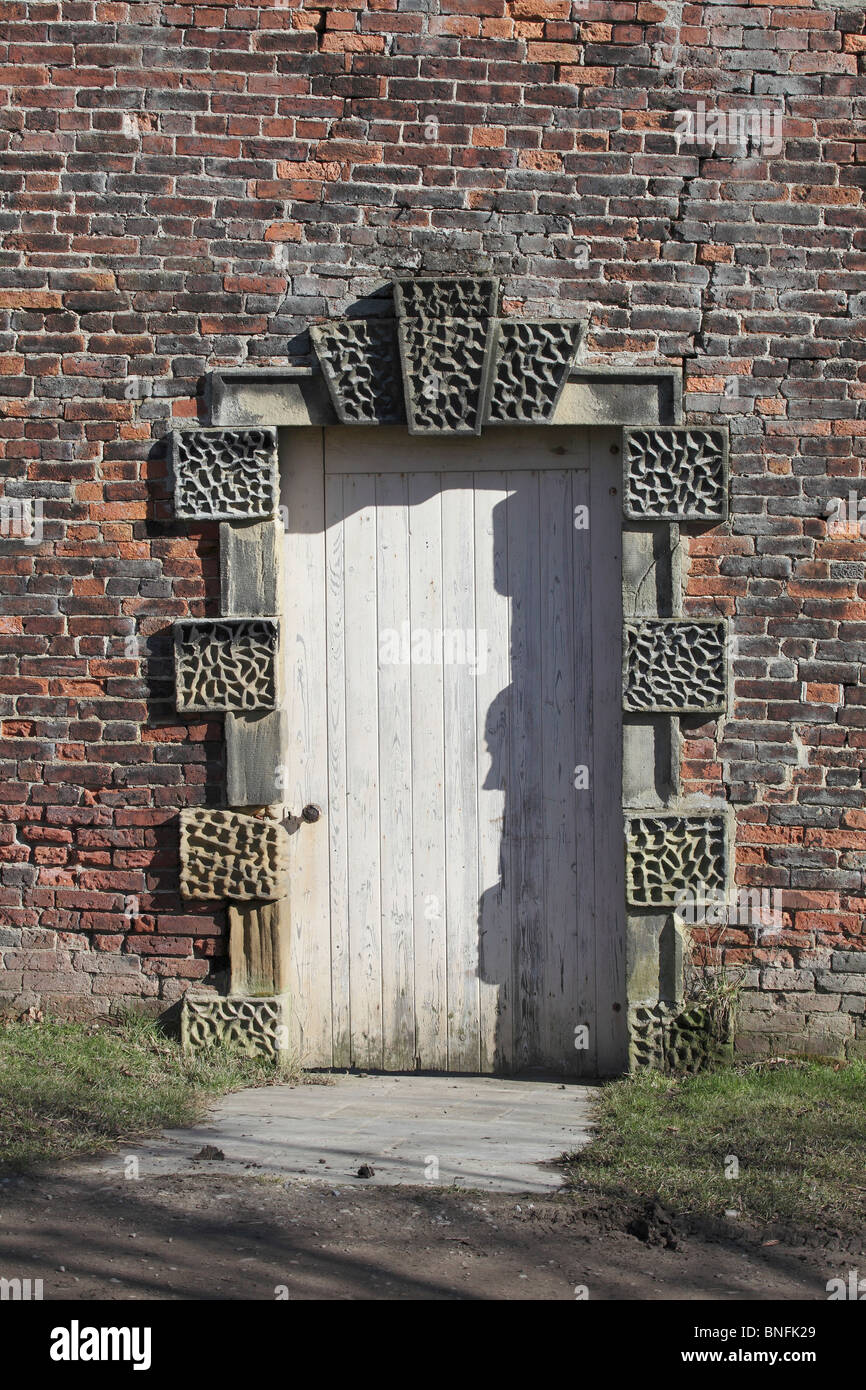 Wooden door in a Rustic brick wall at Harewood Estate, near Leeds, West ...