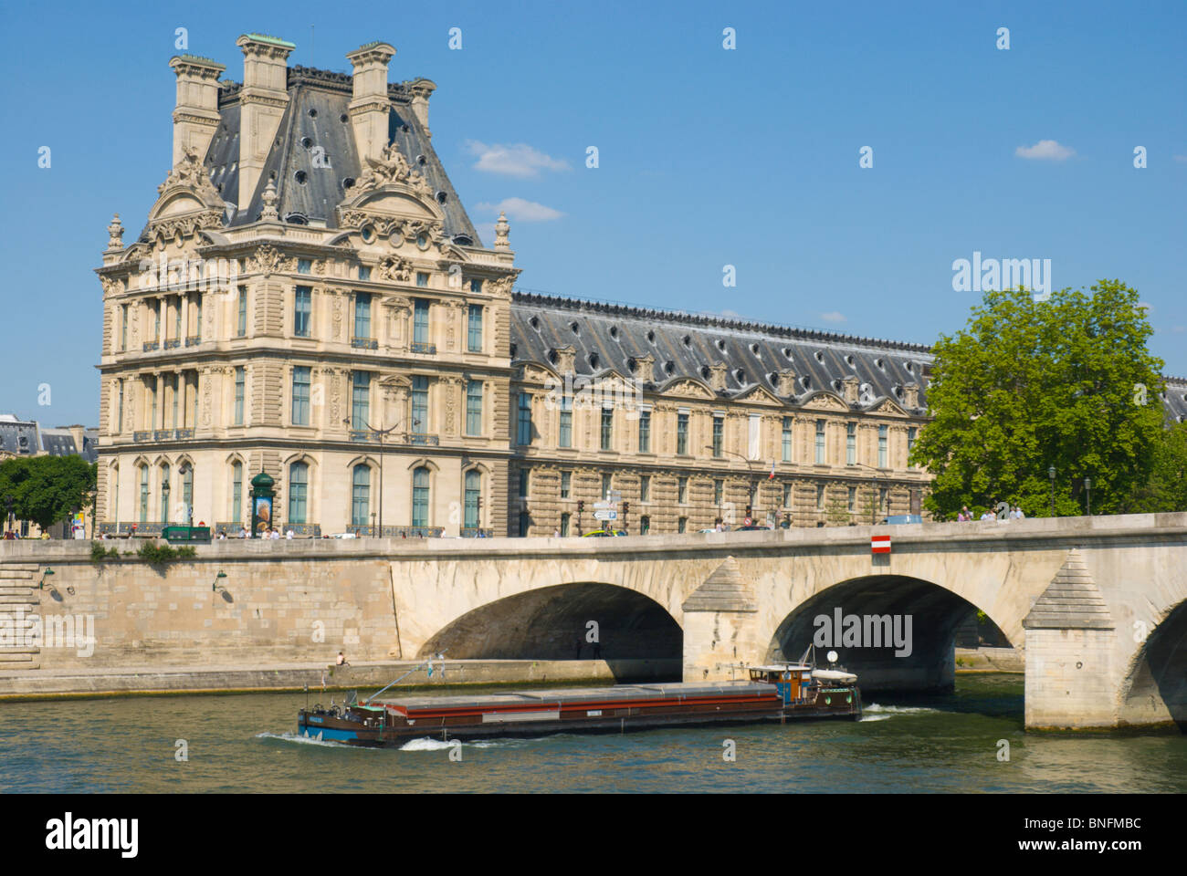 Cargo boat passing Pont Royal bridge and Musee du Louvre Paris France ...
