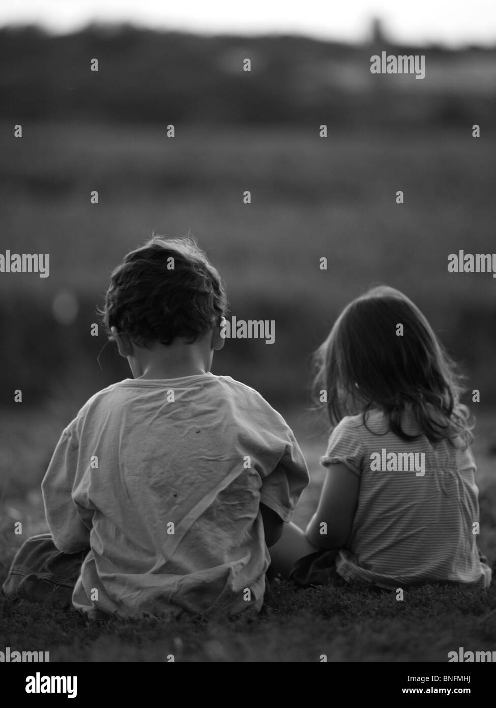 Brother and sister siblings enjoying a quiet evening outdoors at a farm ...