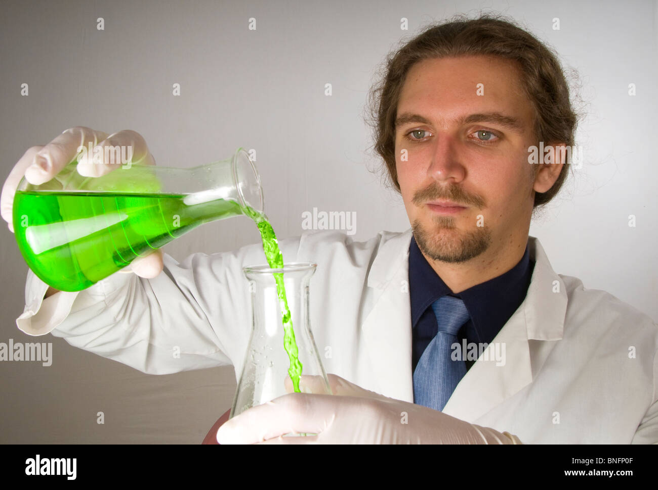 Scientist pouring chemicals in a laboratory Stock Photo - Alamy