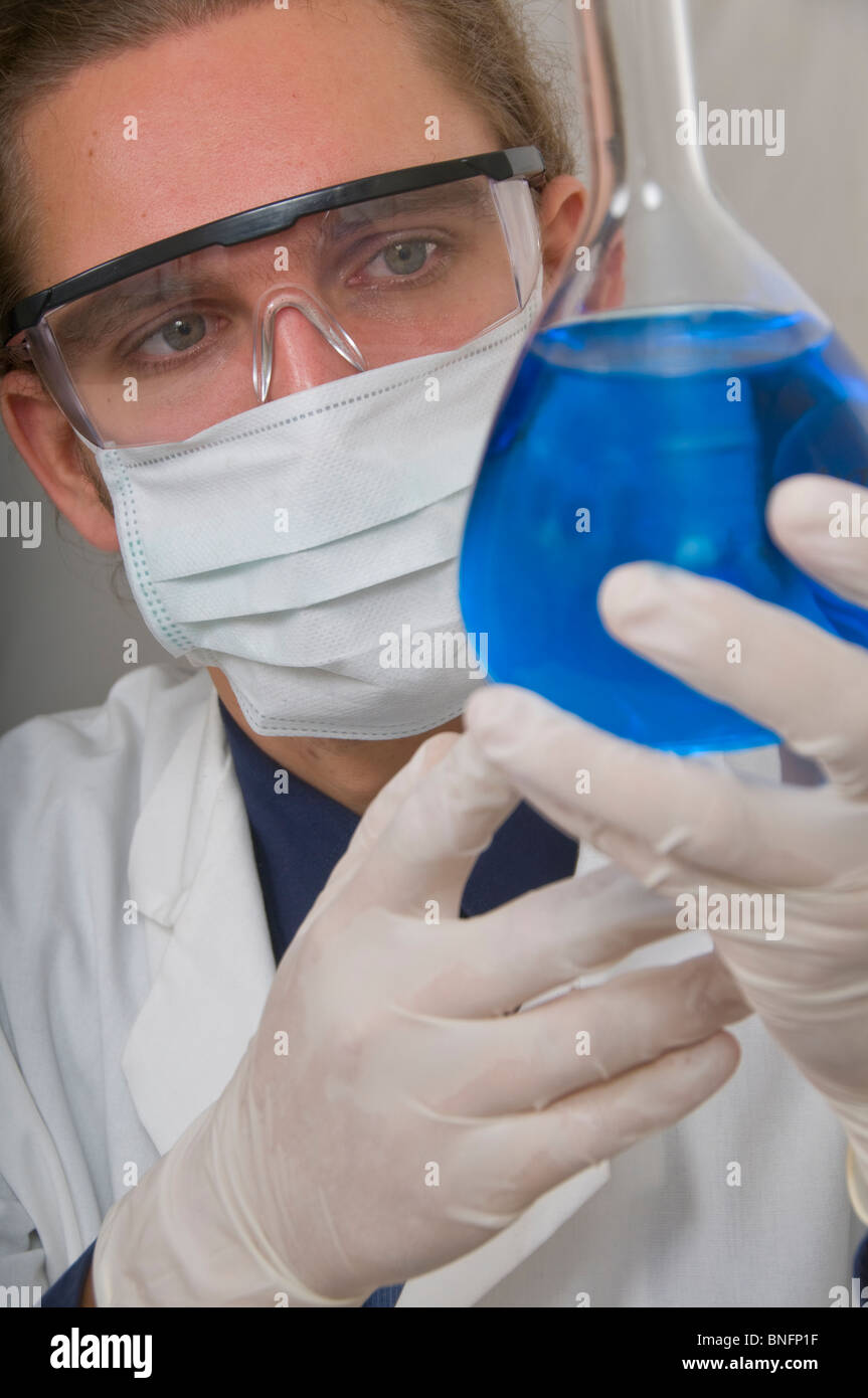 Scientist pouring chemicals in a laboratory Stock Photo - Alamy