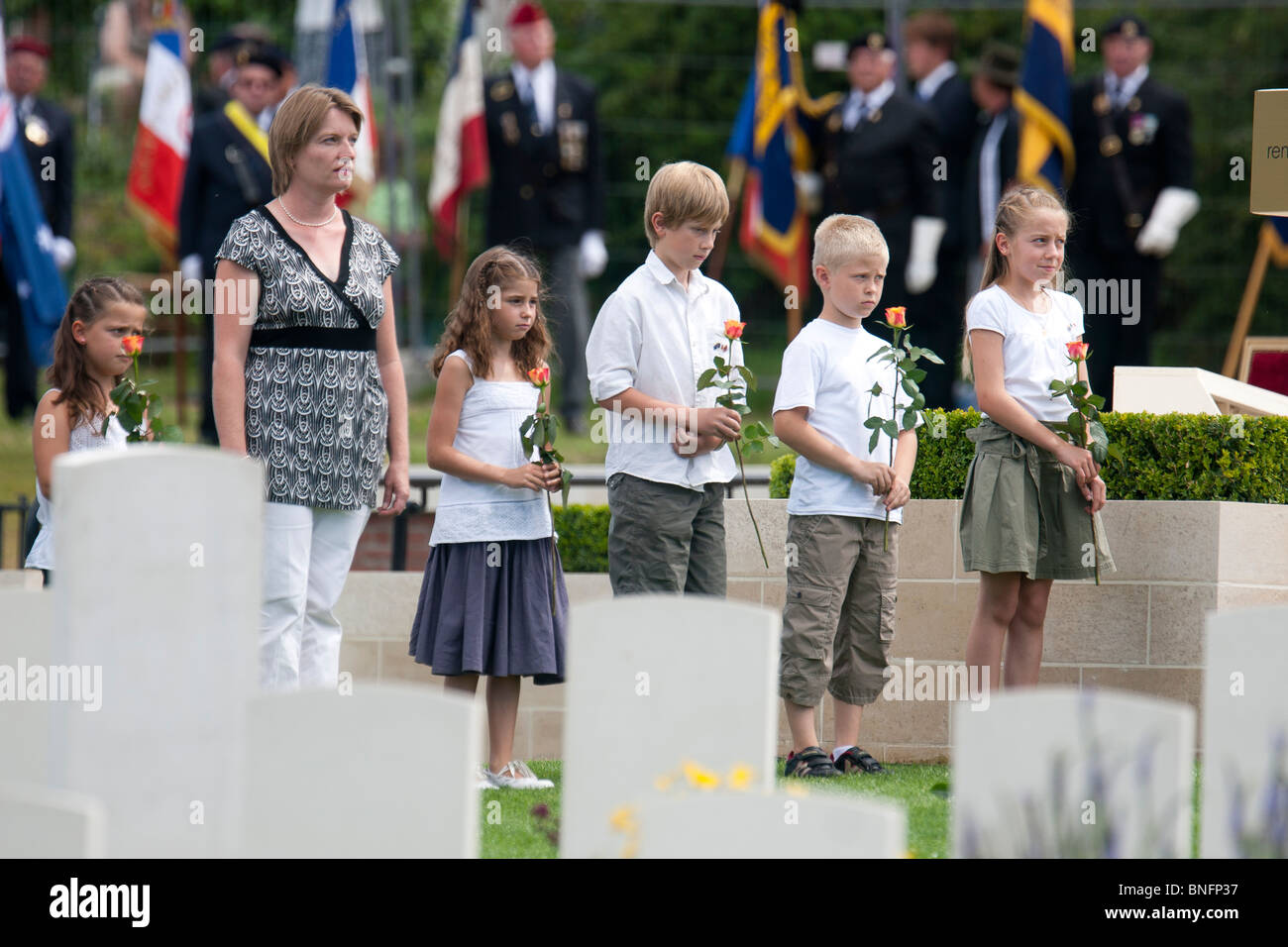 Local school children hold roses during the dedication service for the ...