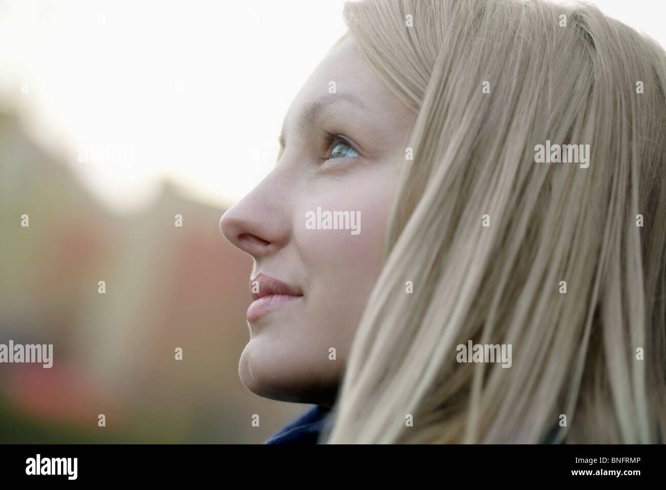 Profile of blonde woman outside looking up Stock Photo - Alamy