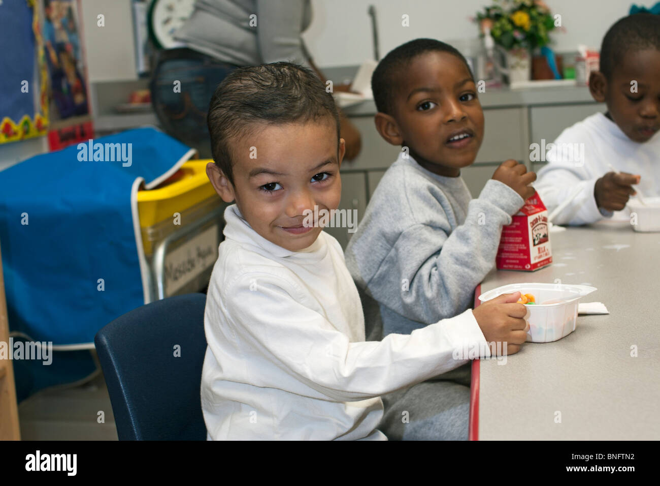 4 year old preschool children eating cereal for breakfast at school ...