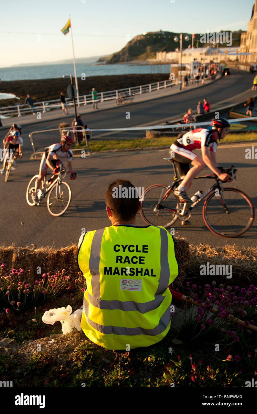 Cycle race marshal watching Cyclists competing in a race around the ...
