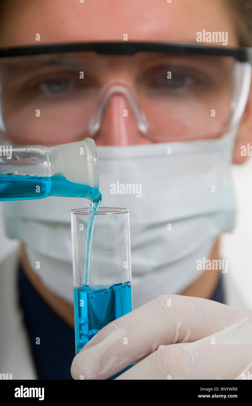 Scientist pouring chemicals in a laboratory Stock Photo - Alamy